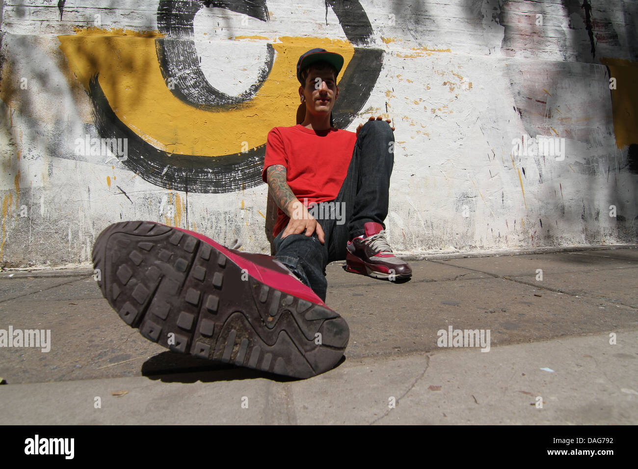 A Rapper leaning against a Graffiti wall Stock Photo - Alamy
