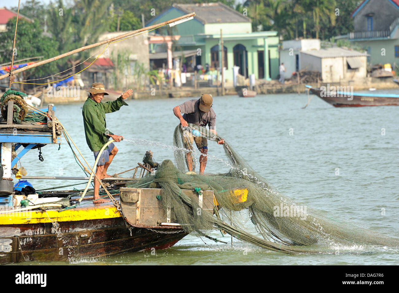 Vietnamese men washing down their fishing nets. Hoi An, Vietnam Stock ...