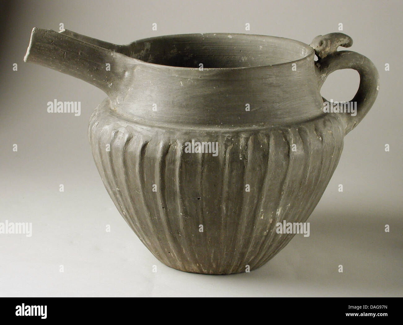 This spouted jug is an example of ancient pottery, featuring a distinct ...