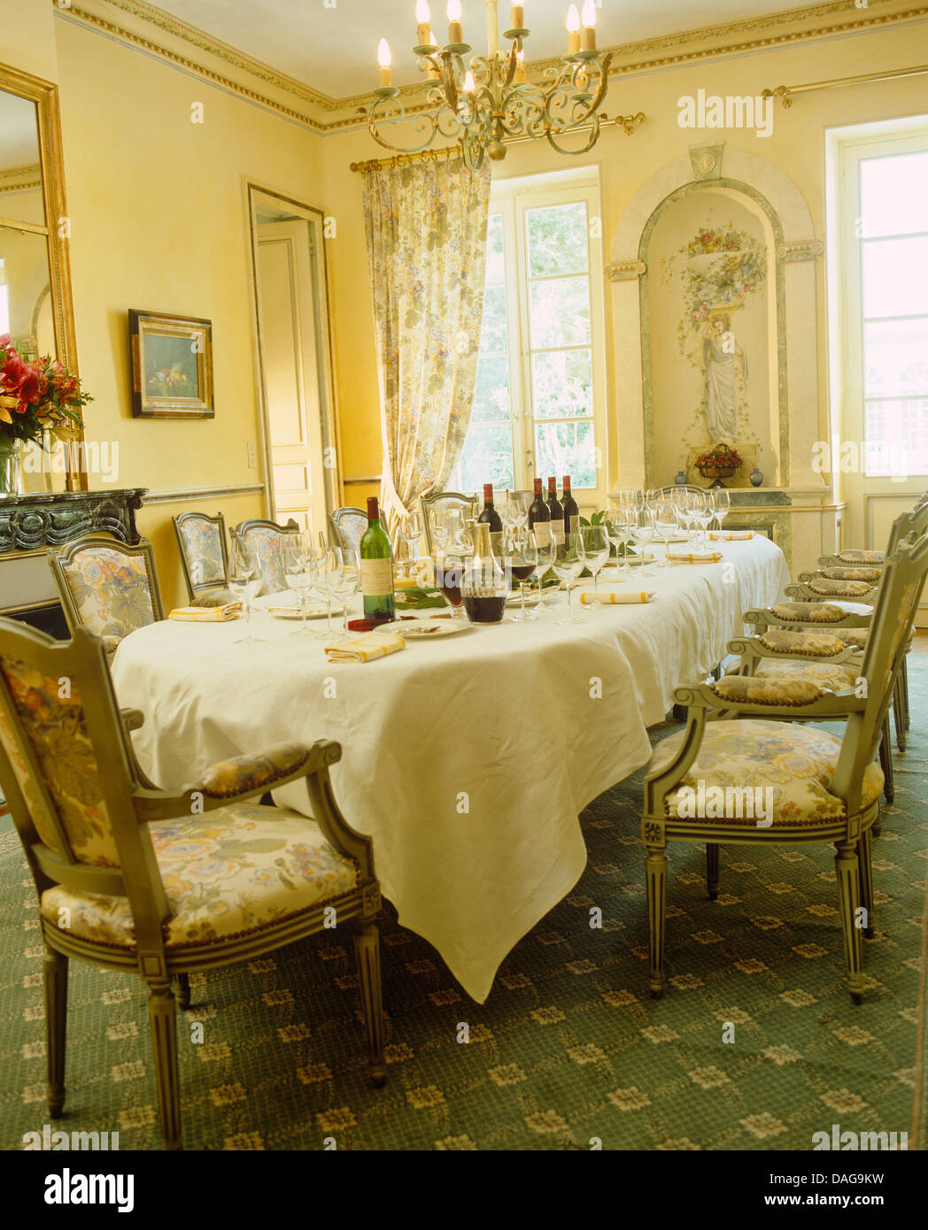White linen cloth on long table set for lunch in opulent country dining ...