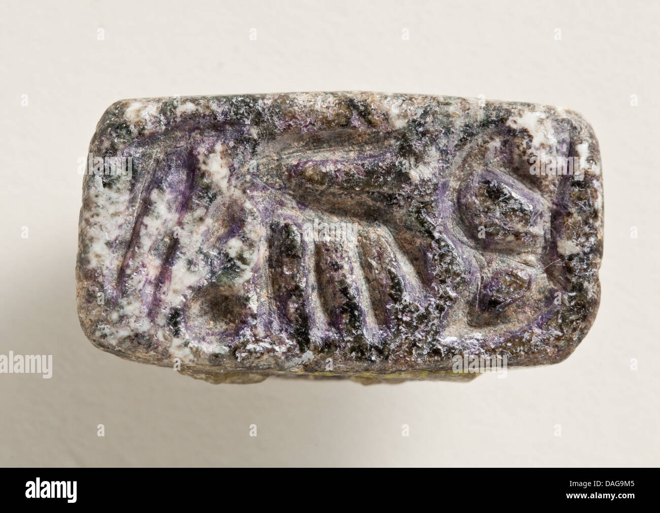 This ancient bronze stamp seal, with a gabled shape, exemplifies the ...