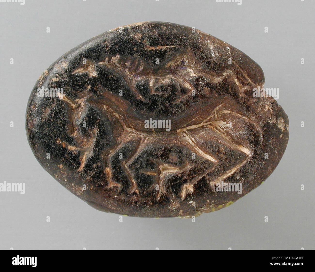 This ancient stamp seal is oval-shaped with a knob handle, featuring ...