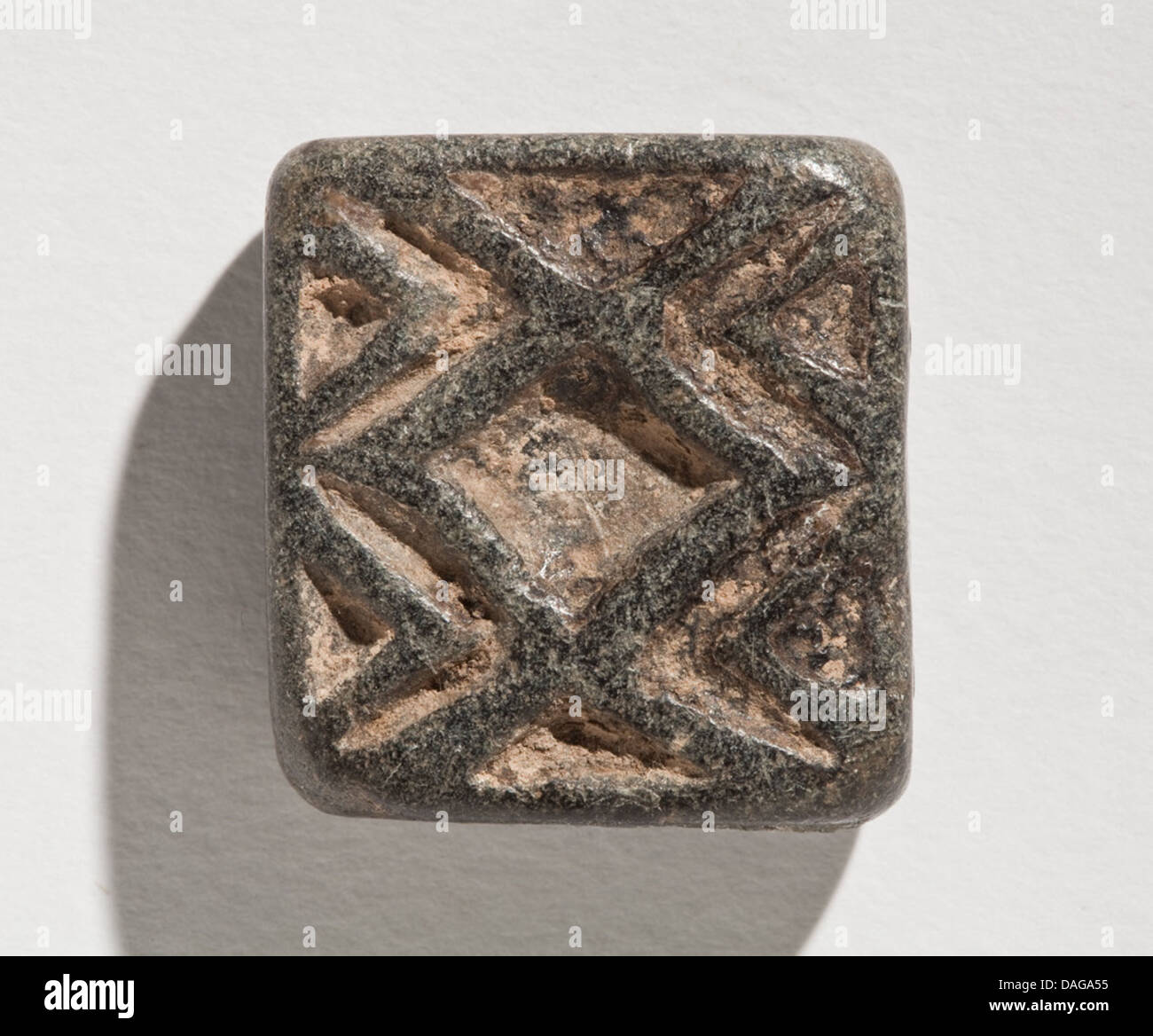 This tabloid stamp seal, an ancient tool used for imprinting designs or ...