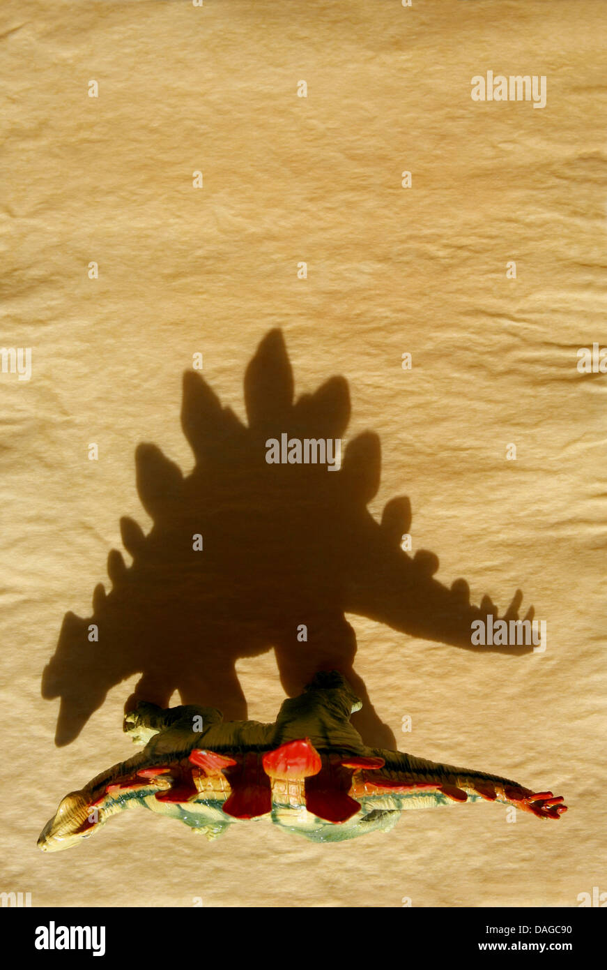 Toy dinosaur Stegosaurus with a long shadow Stock Photo - Alamy