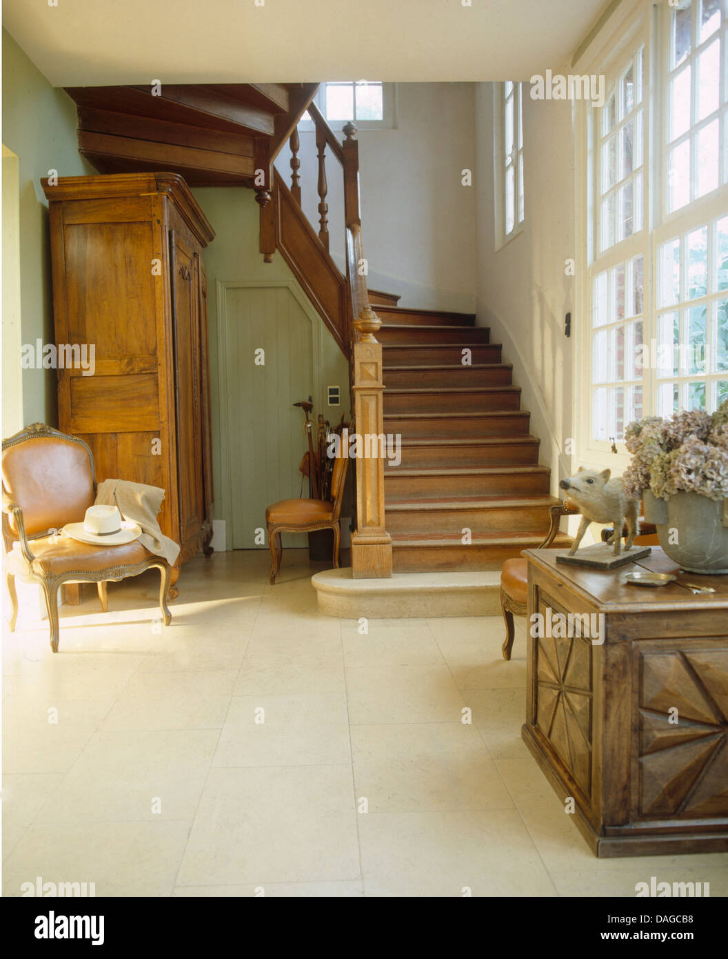 Carved wooden chest and stone flooring in French country hall with ...