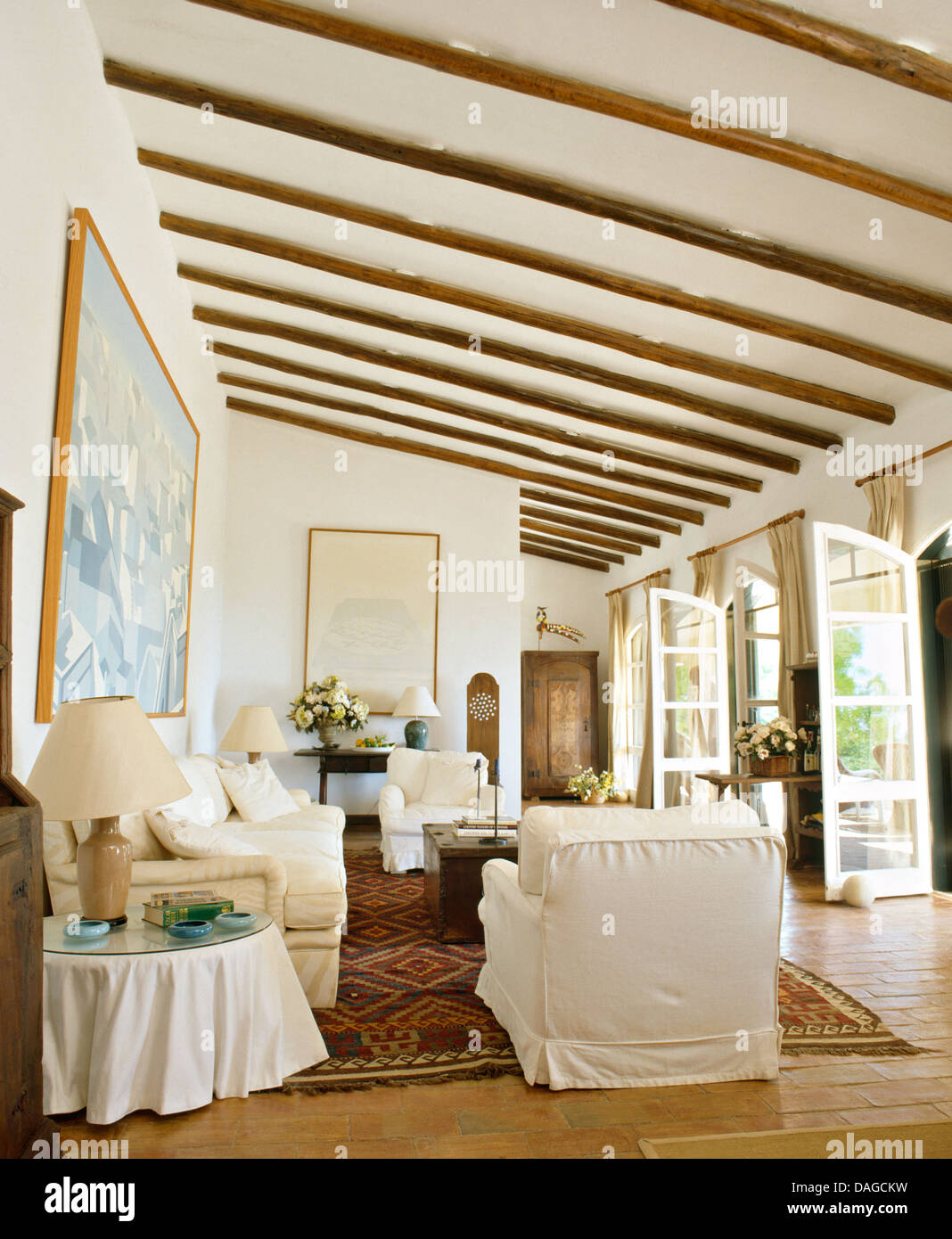 White armchair and sofa in coastal living room with polished wooden ...