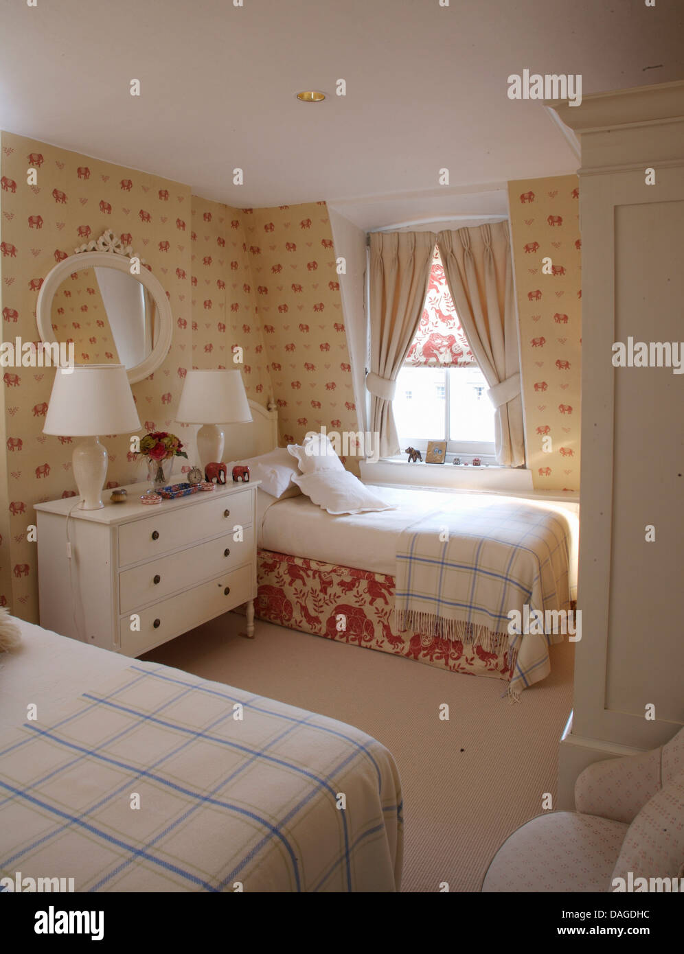 Lamps on white chest of drawers in between twin beds with blue checked ...