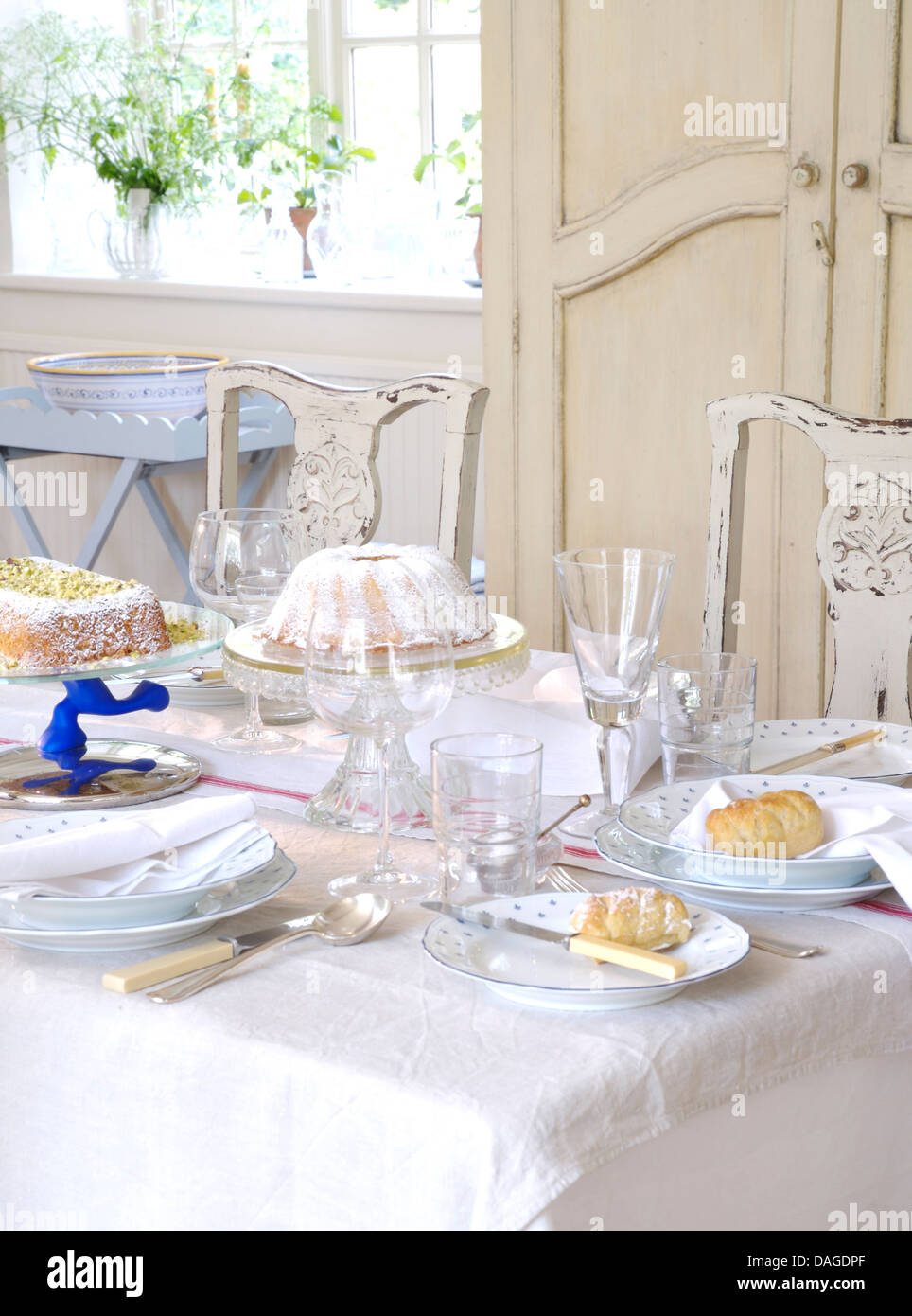 Country dining room with white linen cloth on table set for lunch with ...