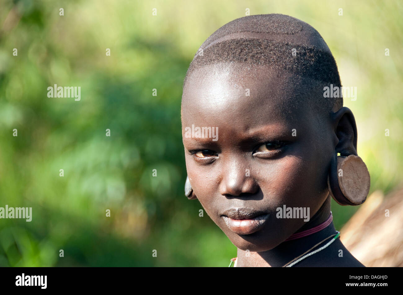 A Suri (Surma) girl with traditional haircut and pierced earlobes ...