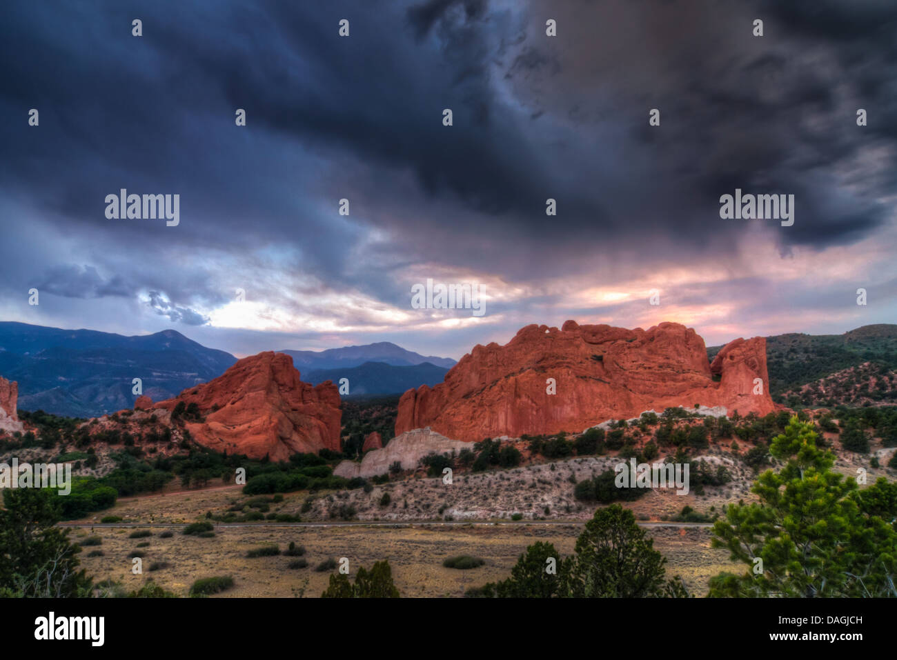 Storm clouds at sunset over Pikes Peak and the red rock formations of ...