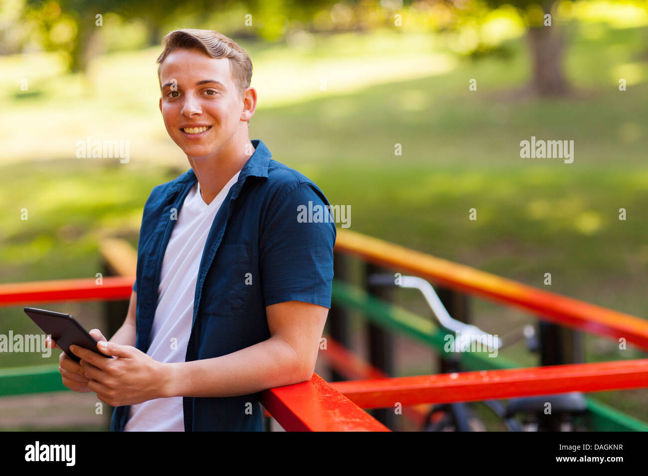handsome teen boy holding tablet computer outdoors Stock Photo - Alamy