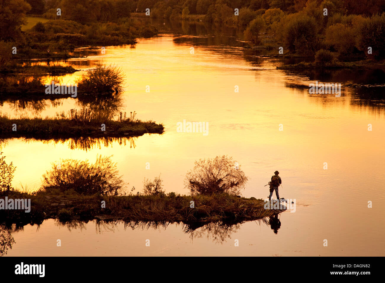 angler standing on Ruhr river dam in evening light, Germany, North ...