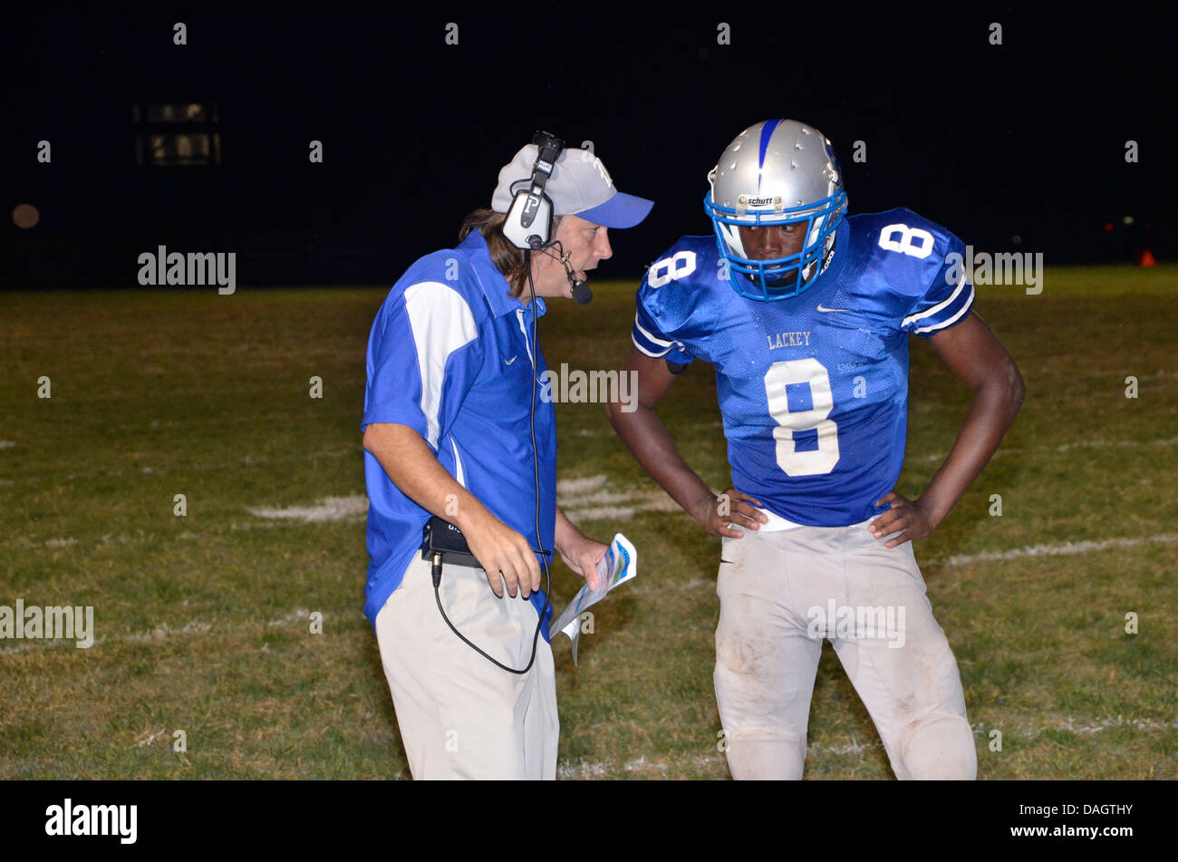 High school coach discusses strategy with high school quarterback ...