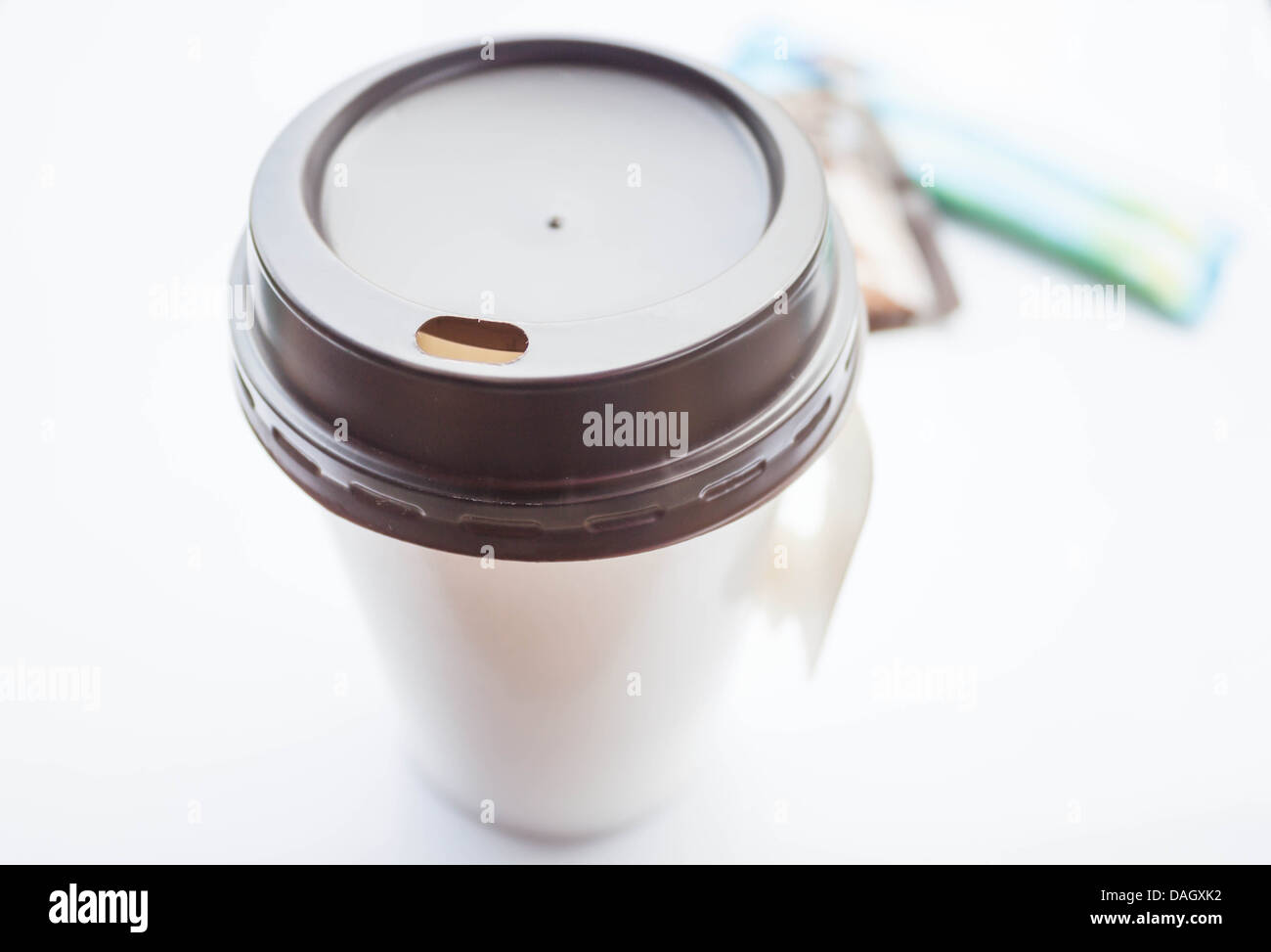 Hot coffee in paper cup with sugar packs on white background Stock ...