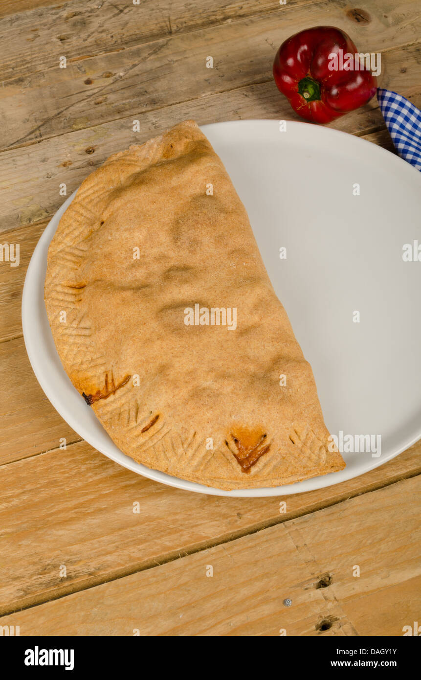 Traditional calzone served on a rustic wooden table Stock Photo - Alamy
