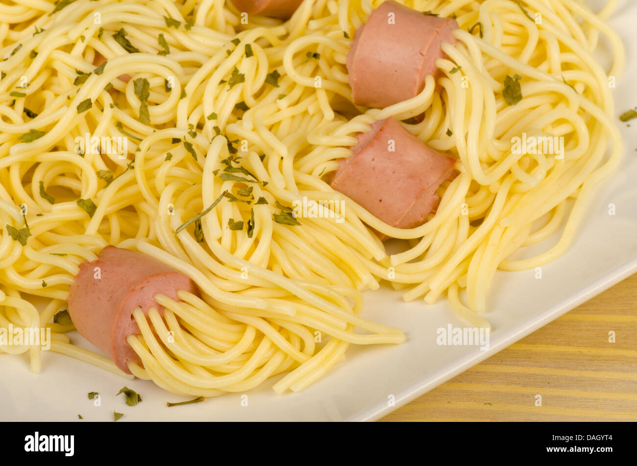 Spaghetti piercing sausages, a kid meal Stock Photo - Alamy