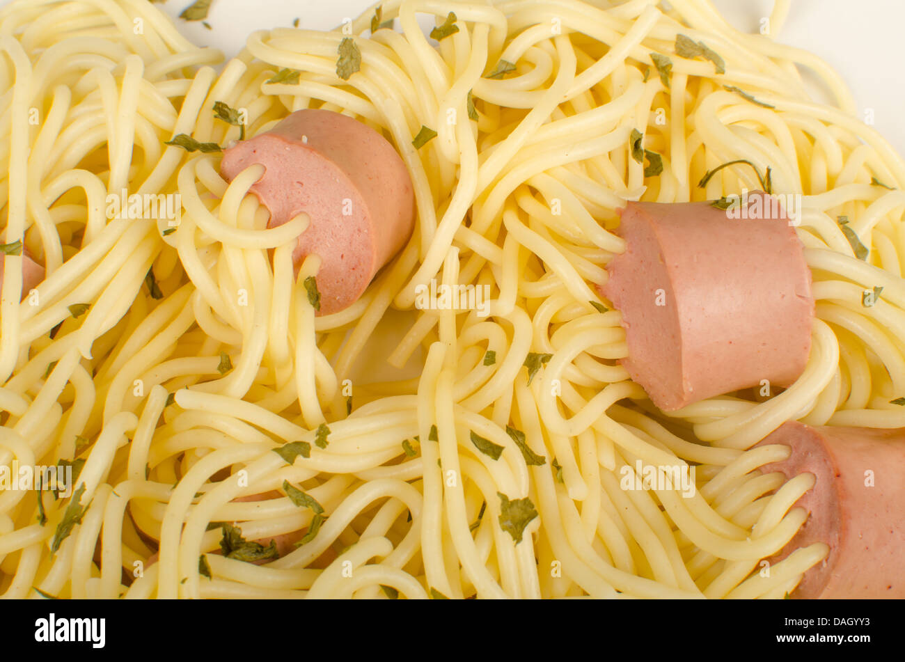 Spaghetti piercing sausages, a kid meal Stock Photo - Alamy