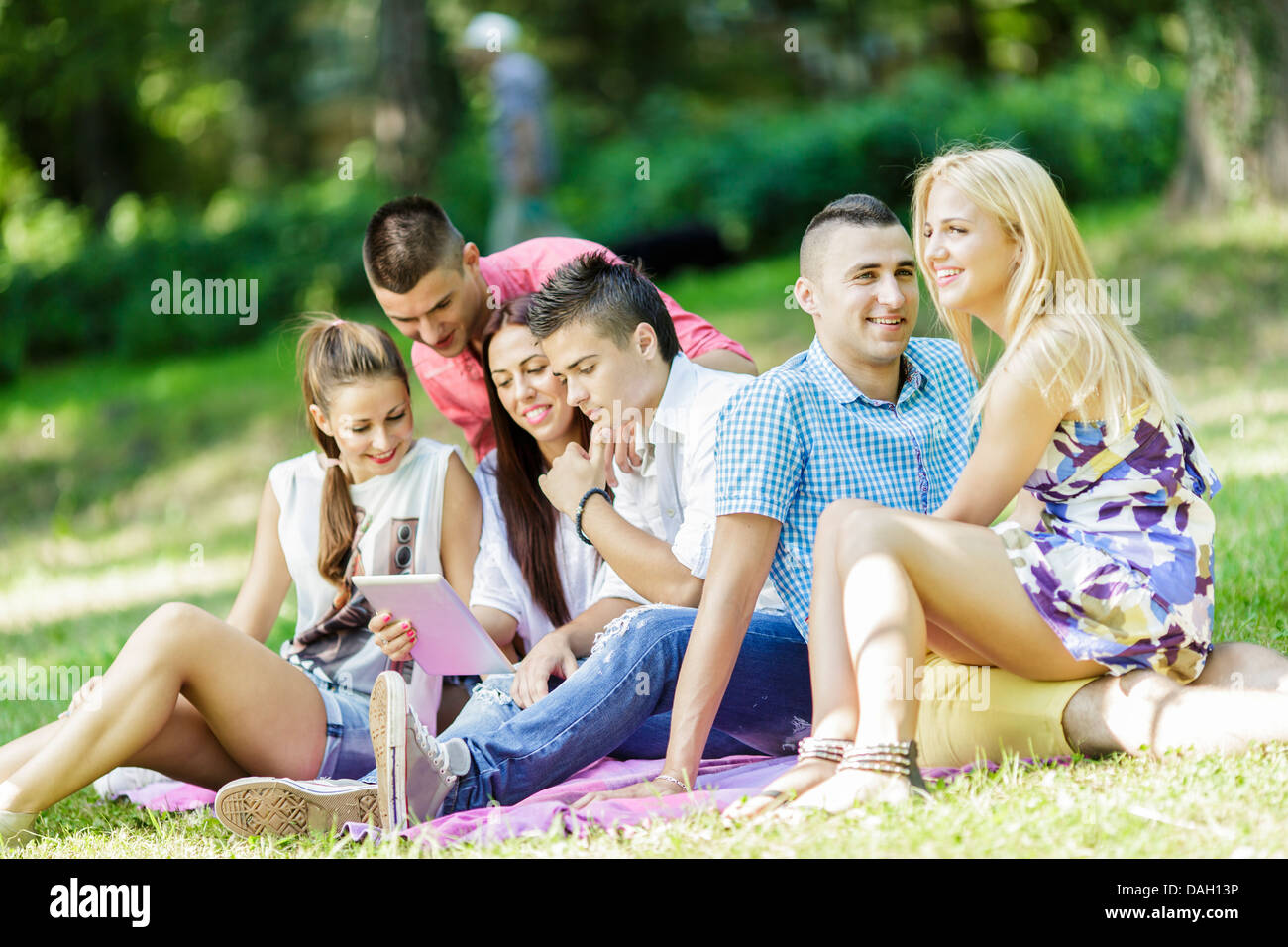 Teenagers in the park with tablet Stock Photo - Alamy