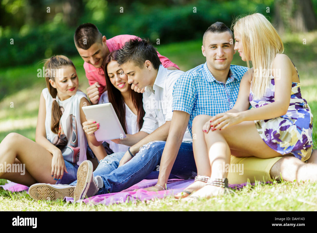 Teenagers in the park with tablet Stock Photo - Alamy
