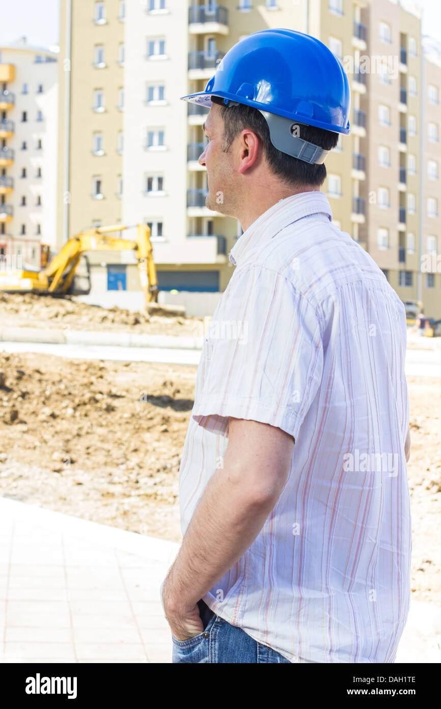 Engineer with blue hard hat on the construction site Stock Photo - Alamy