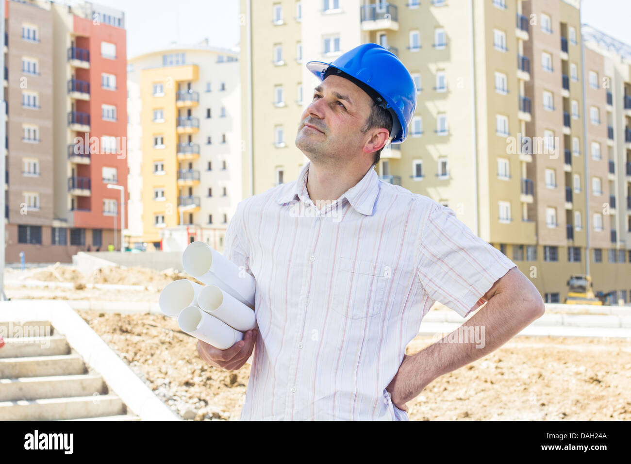 Construction manager holding project on site Stock Photo - Alamy