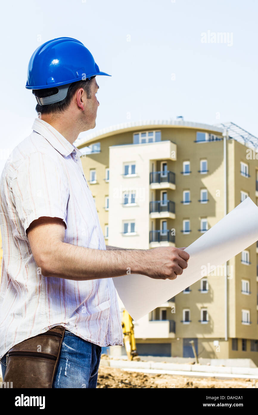 Construction manager holding project and observed on building site ...