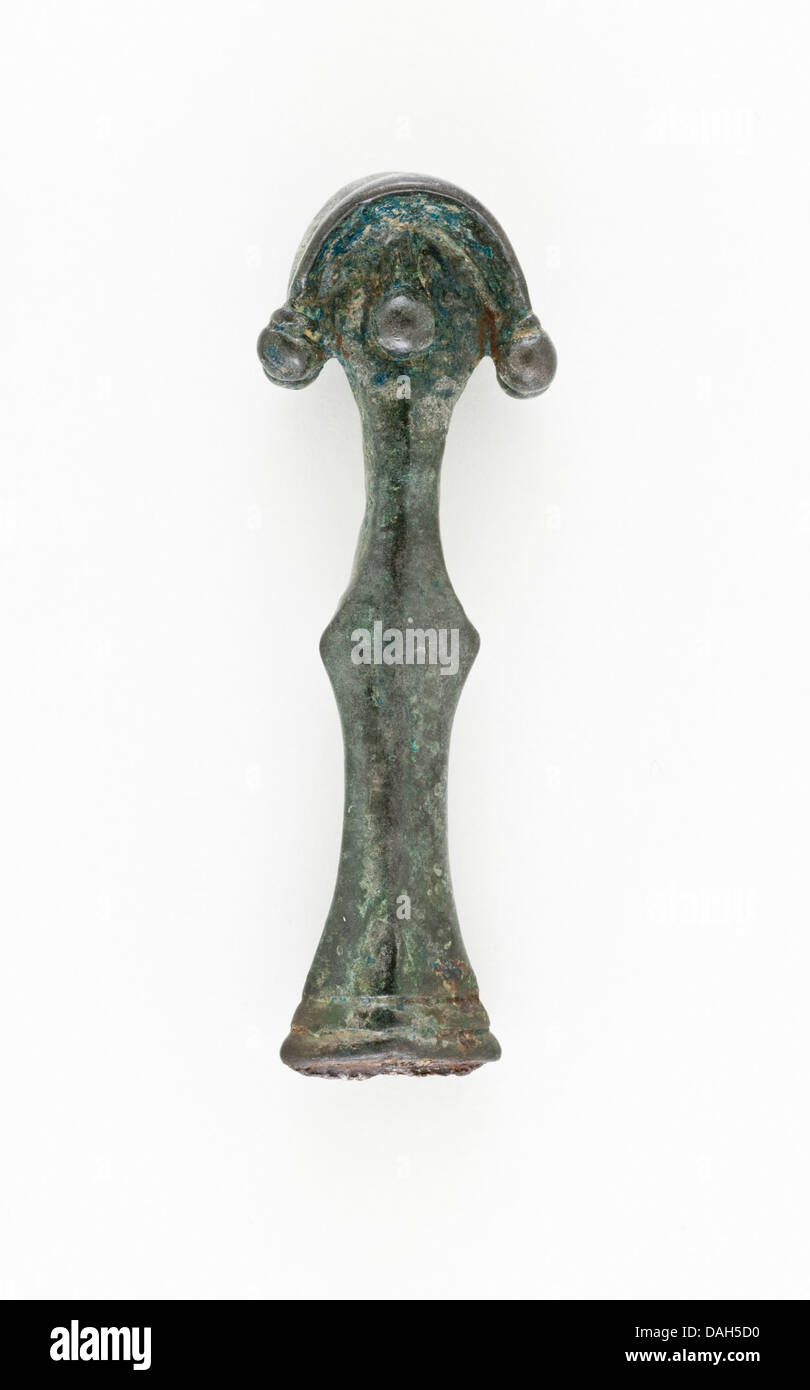 A bronze dagger hilt featuring intricate craftsmanship, held in LACMA’s ...