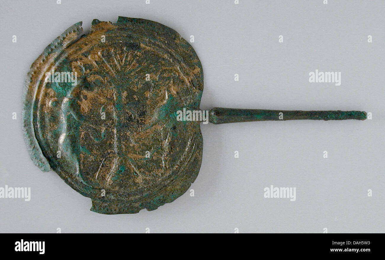 This disc-headed pin is crafted from metal, with intricate detailing ...