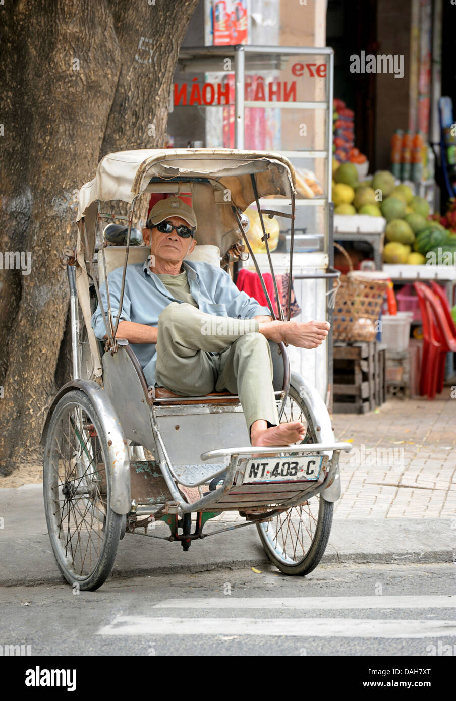 Cyclo rickshaw driver on his rickshaw, resting, Nha Trang, Vietnam ...