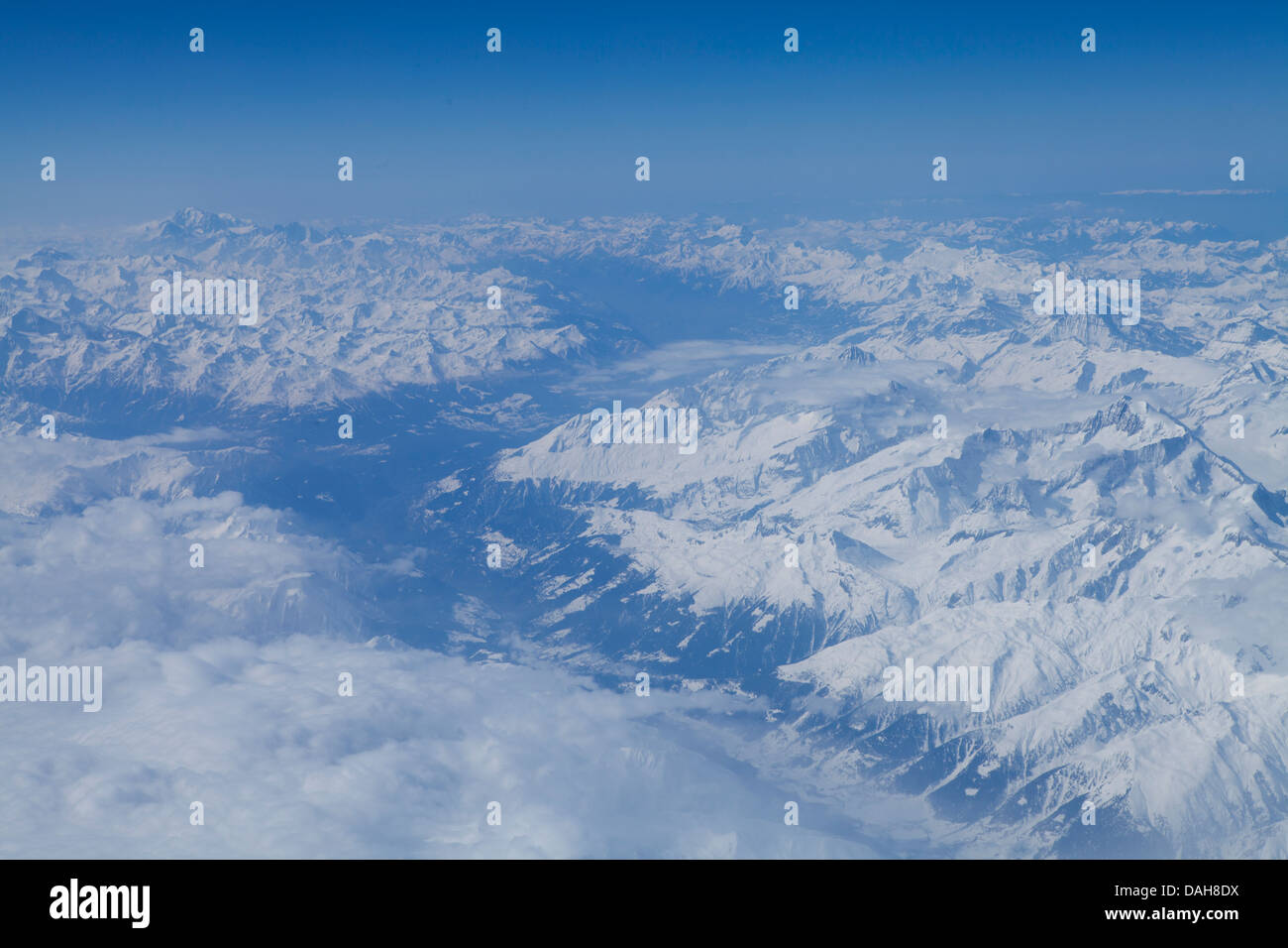 The alps, mountains covered in snow, with clouds, blue sky Stock Photo ...