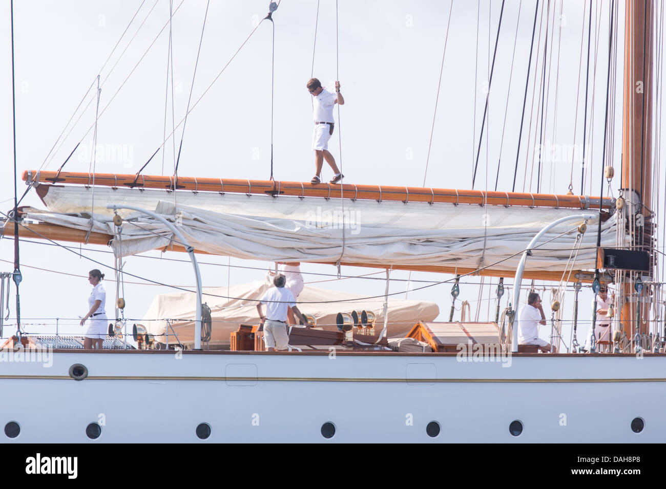 A deck hand rigs the sails on the 196-foot sailing yacht Germania Nova ...