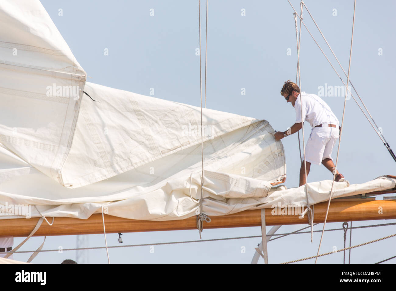 A deck hand rigs the sails on the 196-foot sailing yacht Germania Nova ...