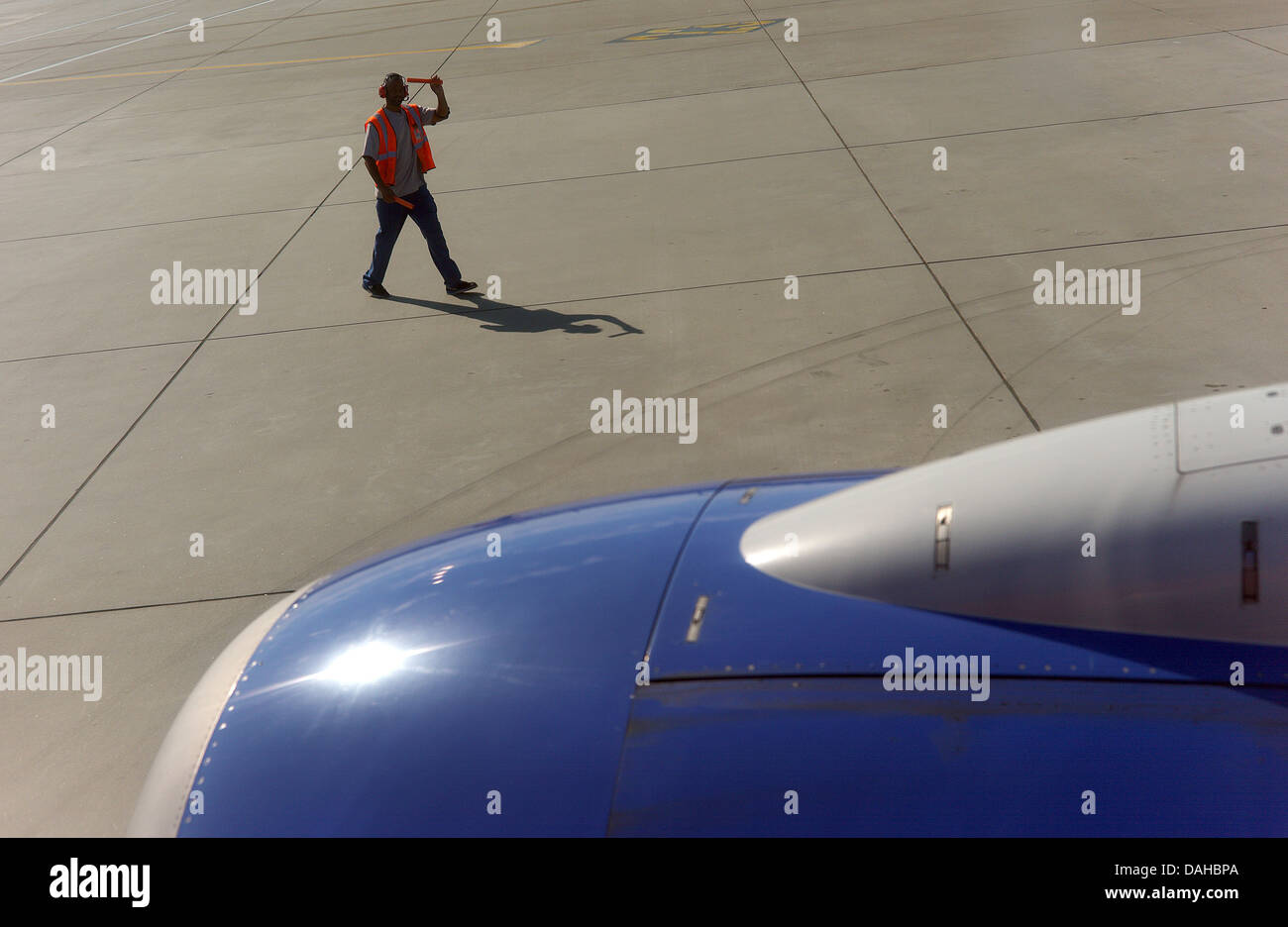 Man guides a jet on runway Stock Photo - Alamy