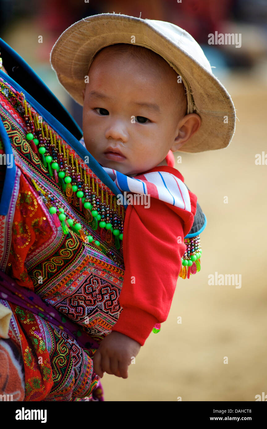 Flower Hmong child carried on mother's back. Distinctive tribal costume ...
