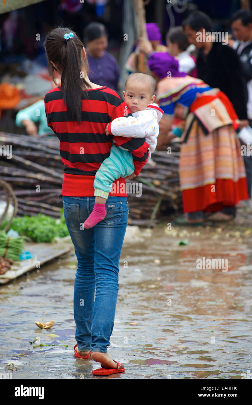 Vietnamese girl carrying small child at bac Ha market, Lao Cai Province ...