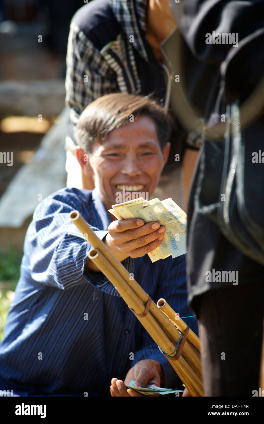 Hmong man buying a handmade bamboo musical instrument, Coc Ly market ...