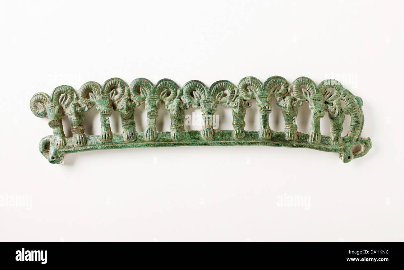 This harness fitting is an ancient artifact, crafted from metal, likely ...