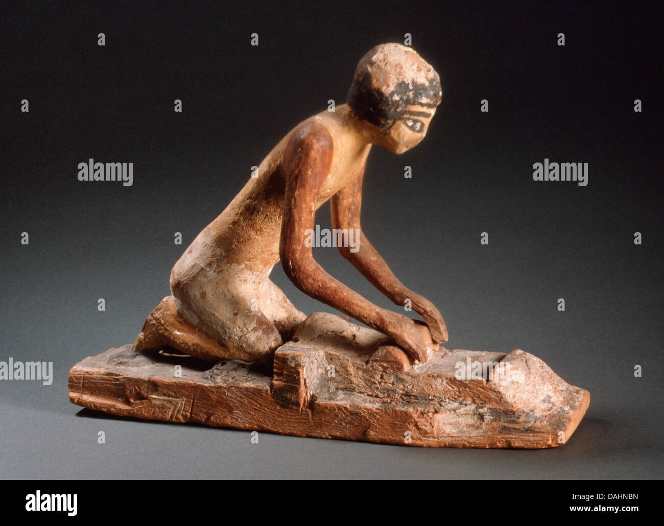This model of a woman grinding grain is an ancient artifact depicting ...