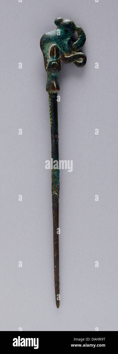 A finely crafted pin, made from bronze, featuring detailed artistry ...
