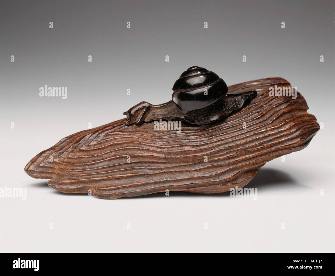 This artwork features a detailed sculpture of a snail on a log ...