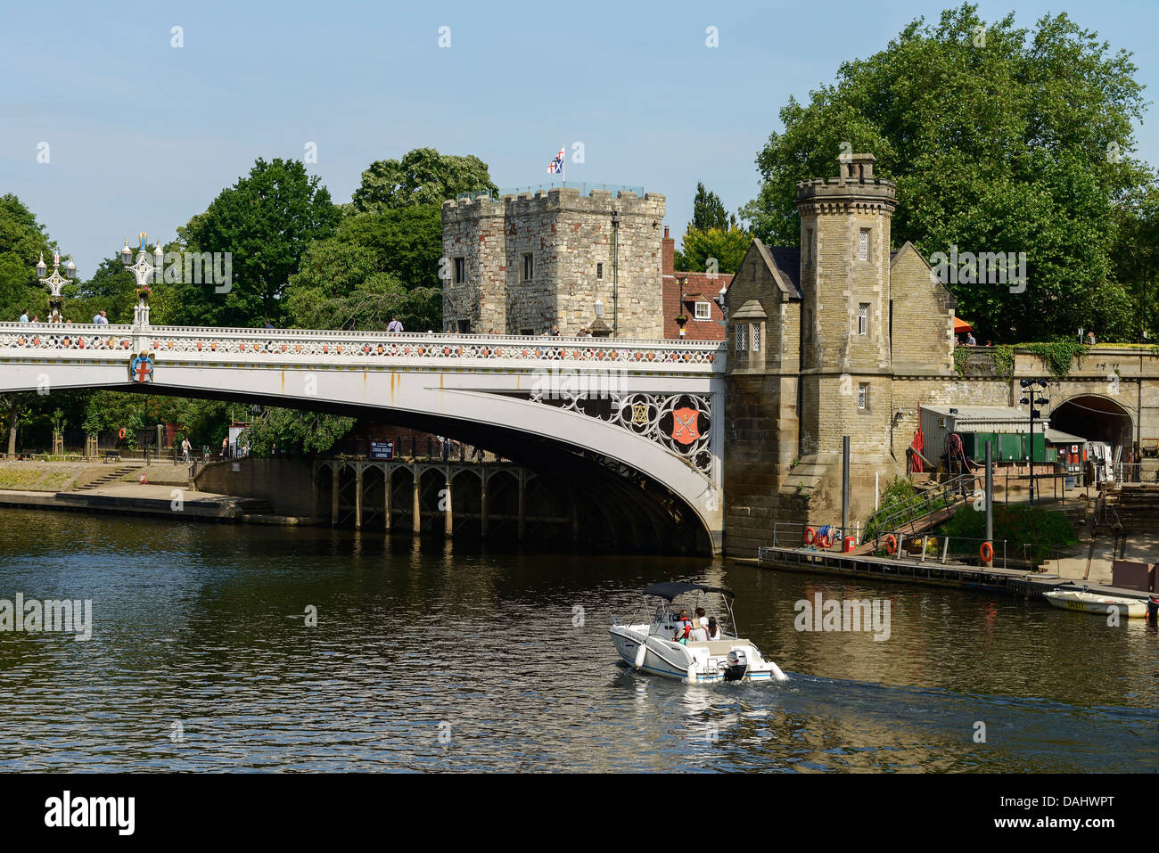 A small pleasure boat on the River Ouse passes under Lendal Bridge in ...