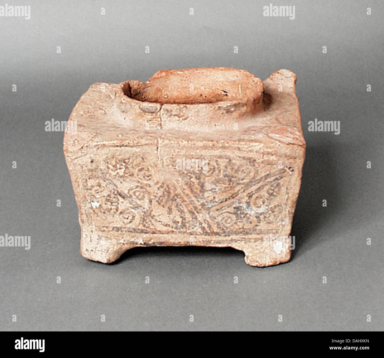 This vessel, made from ceramic, features intricate designs and forms ...