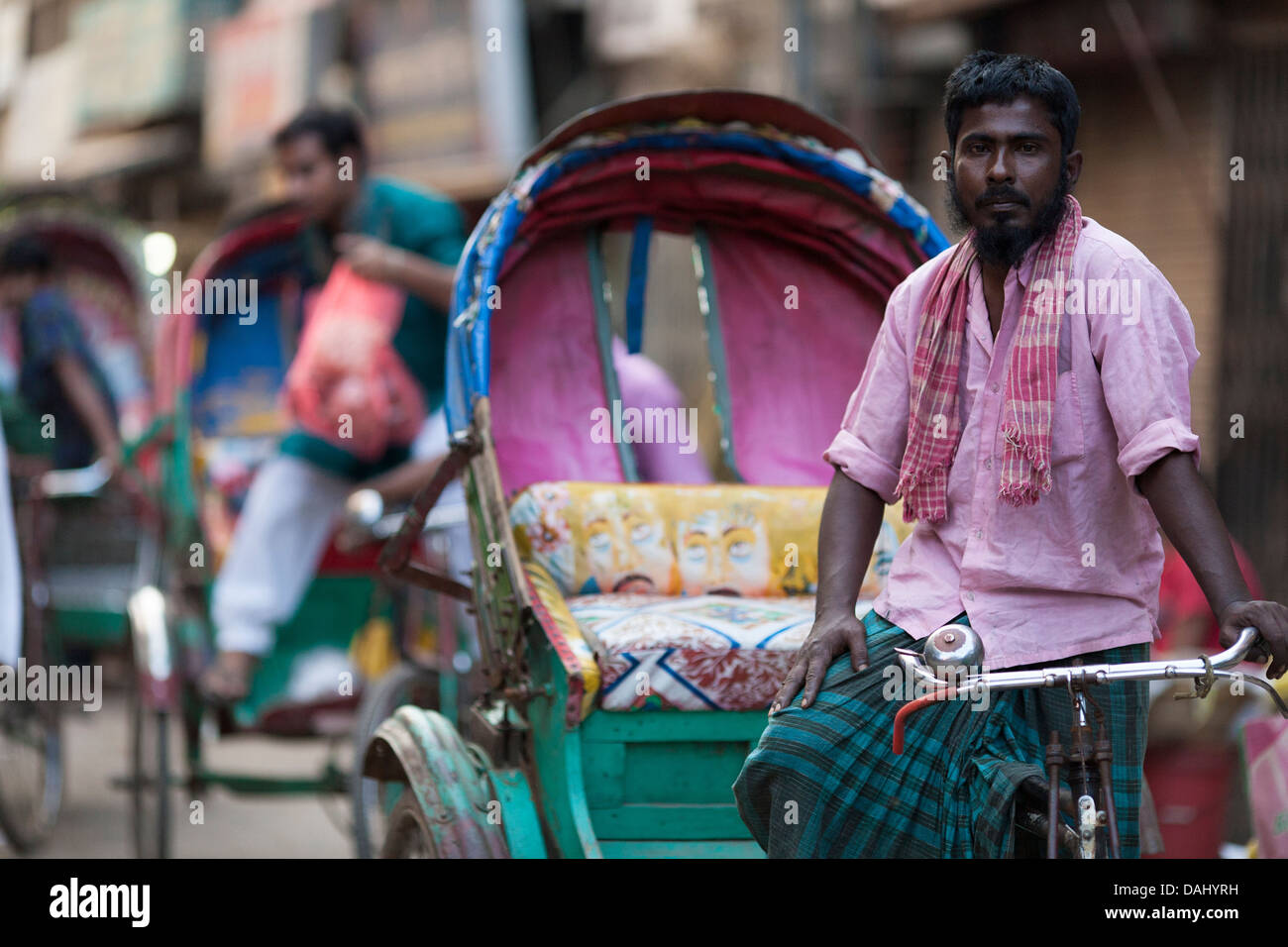 A colorful rickshaw driver on his bike in the historic old city of ...