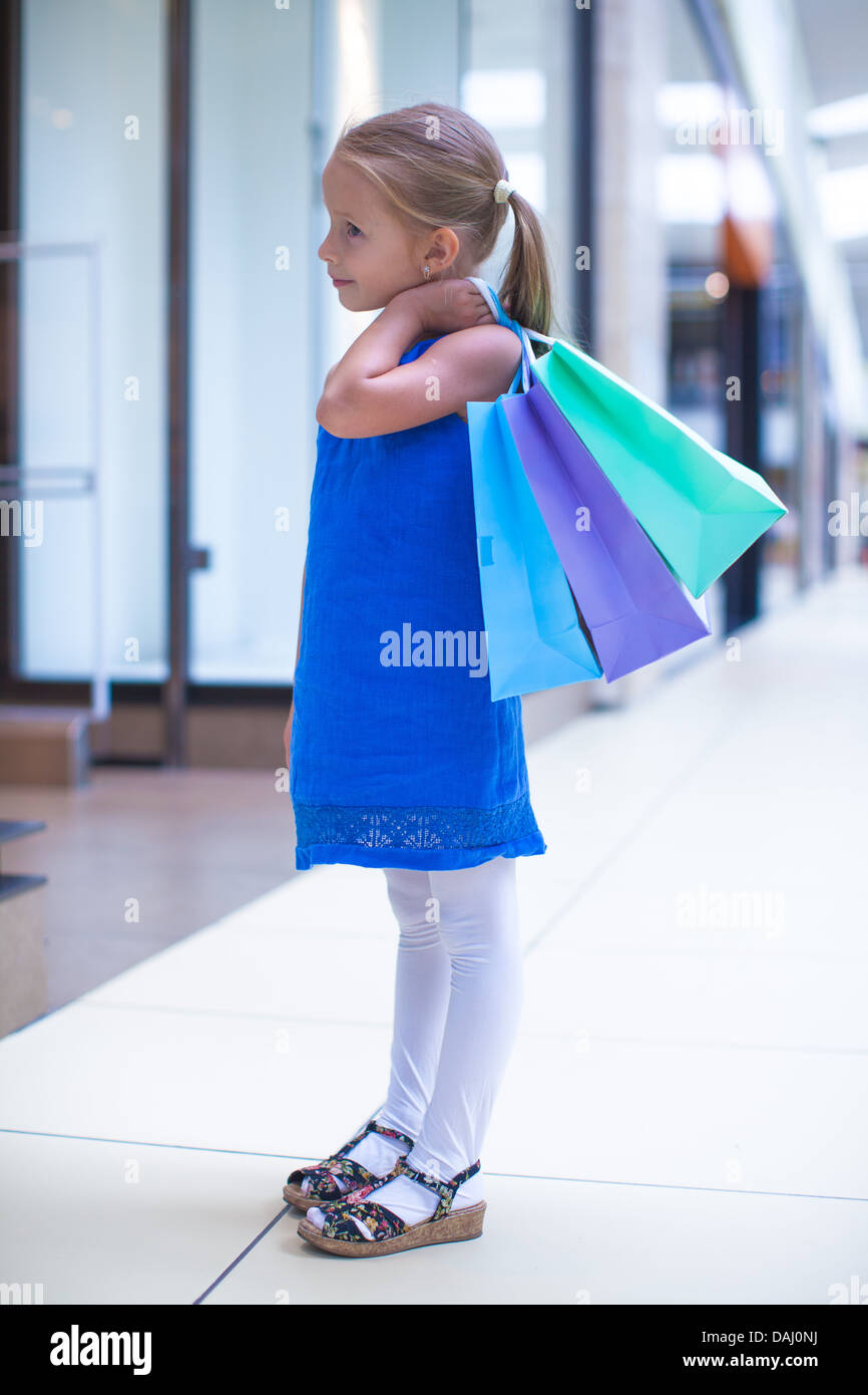Little fashion girl with packages in a large shopping center Stock ...