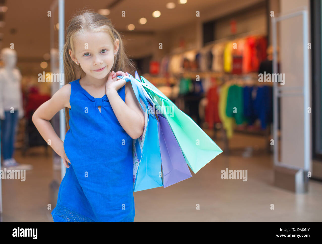 Little fashion girl with packages in a large shopping center Stock ...
