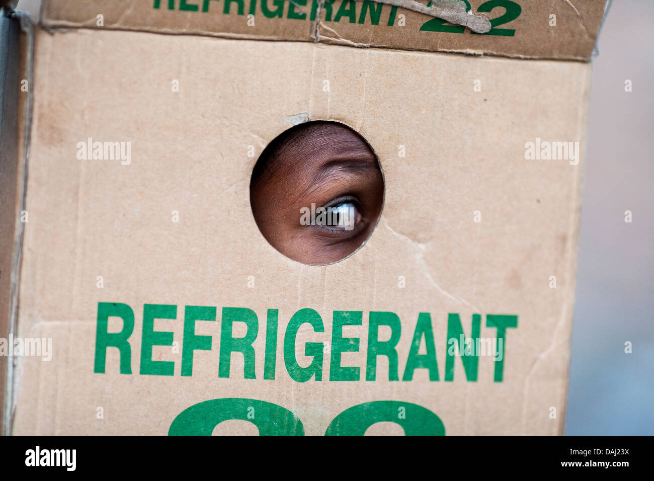 A child plays with an empty cardboard refrigerant box in a slum in ...
