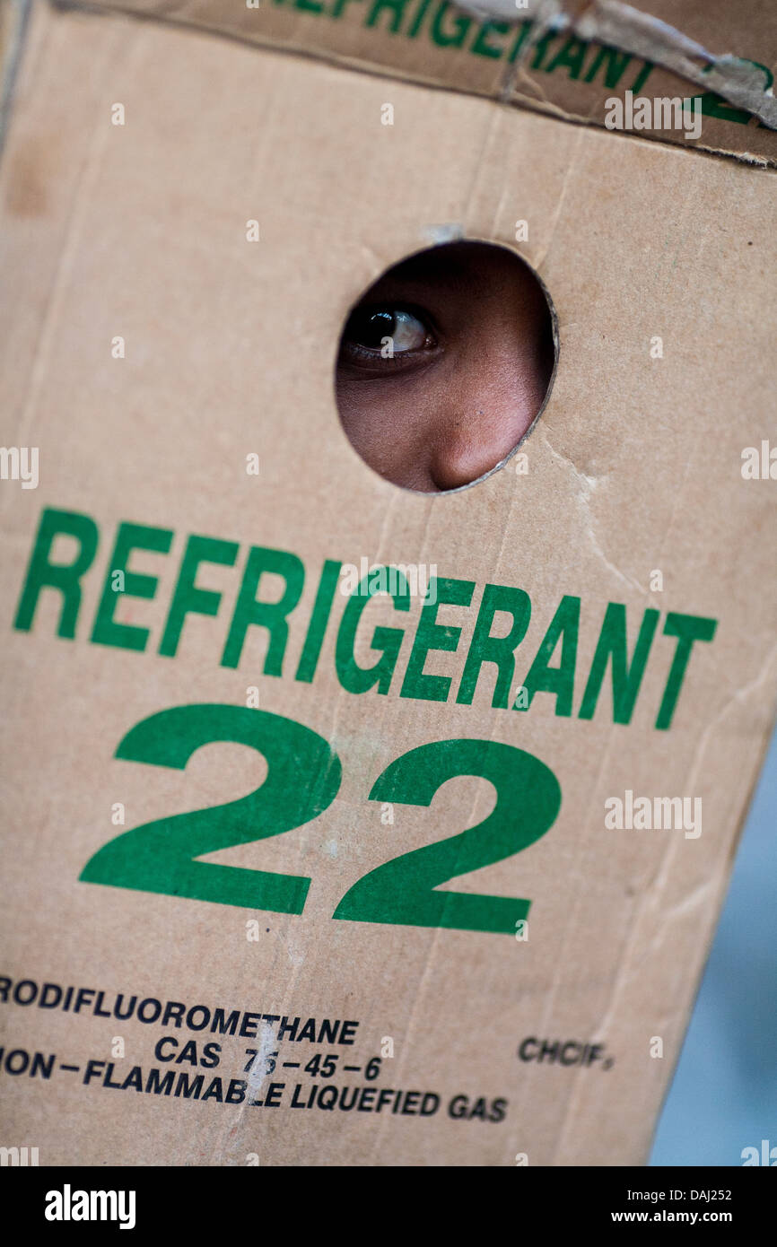 A child plays with an empty cardboard refrigerant box in a slum in ...