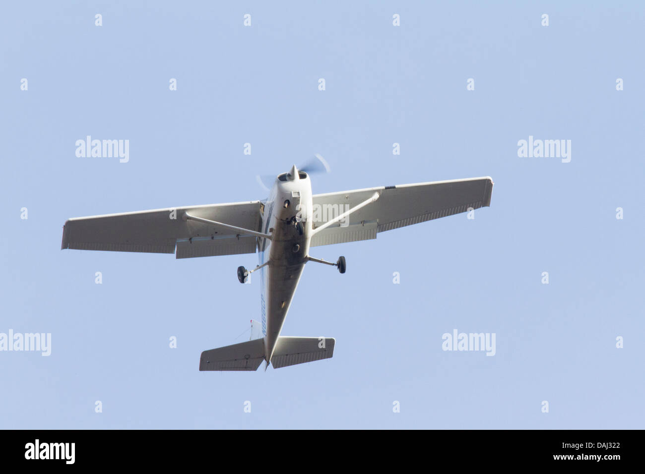 Small plane flying seen from land / under Stock Photo - Alamy