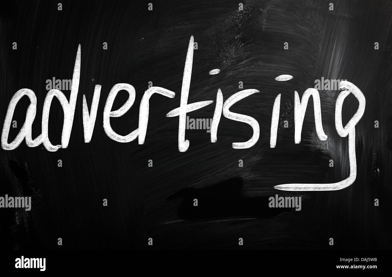 The word "advertising" handwritten with white chalk on a blackboard ...