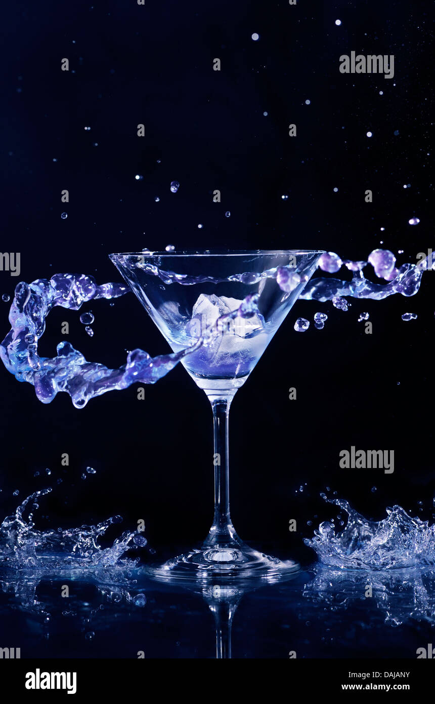 Splashing cocktail over dark background Stock Photo - Alamy